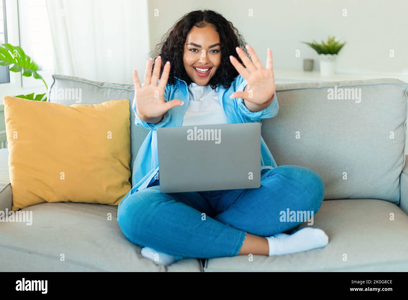 Black Woman Using Laptop Stretching Hands Waving Hello At Home Stock ...