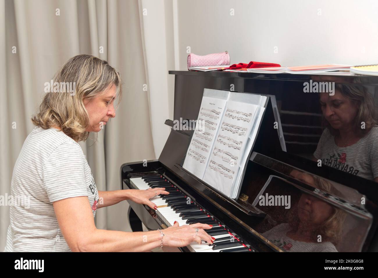 Beautiful Brazilian pianist woman touching piano keys, playing upright ...