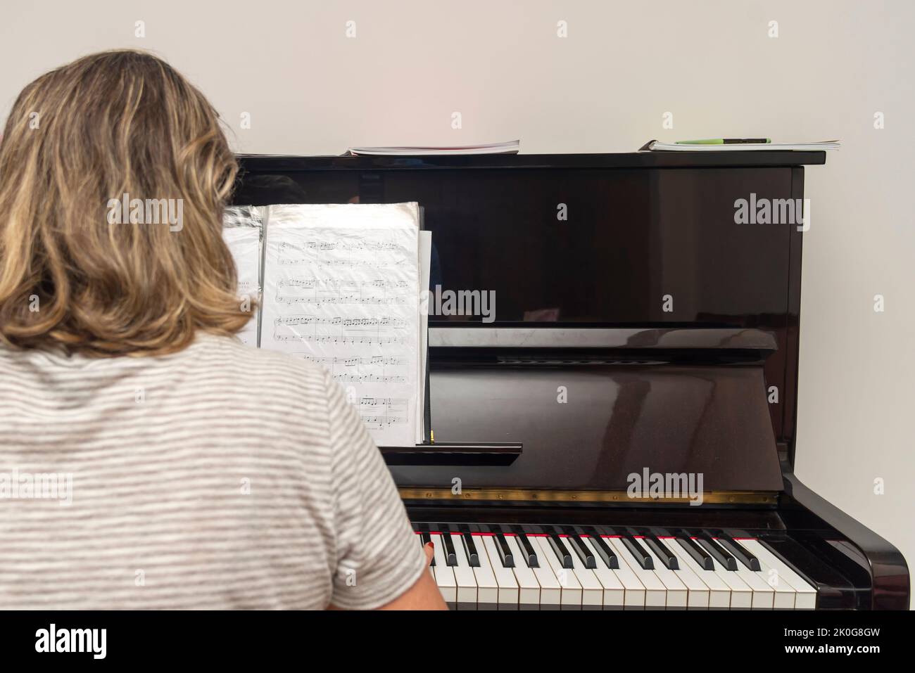 Beautiful Brazilian pianist woman touching piano keys, playing upright ...
