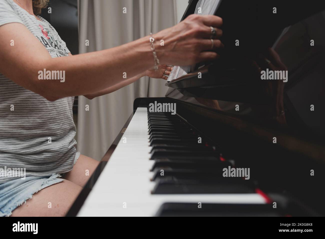 Woman preparing to play upright piano. Concept music teaching and arts ...