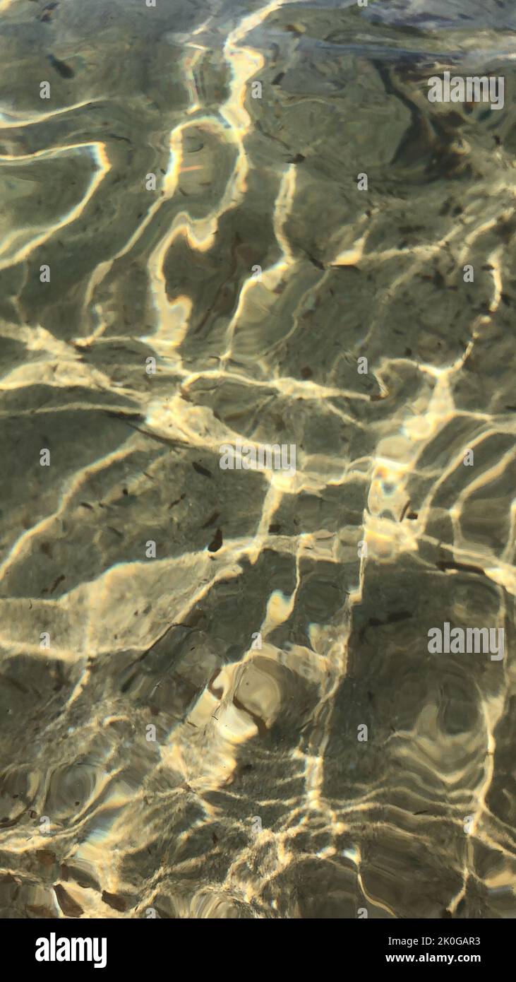 Water reflection texture on the beach sand. Clean transparent water and ...