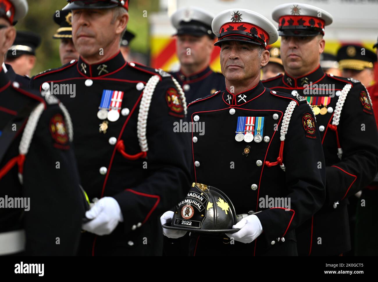 Members of an honour guard carry in the helmets of fallen firefighters at the Canadian ...