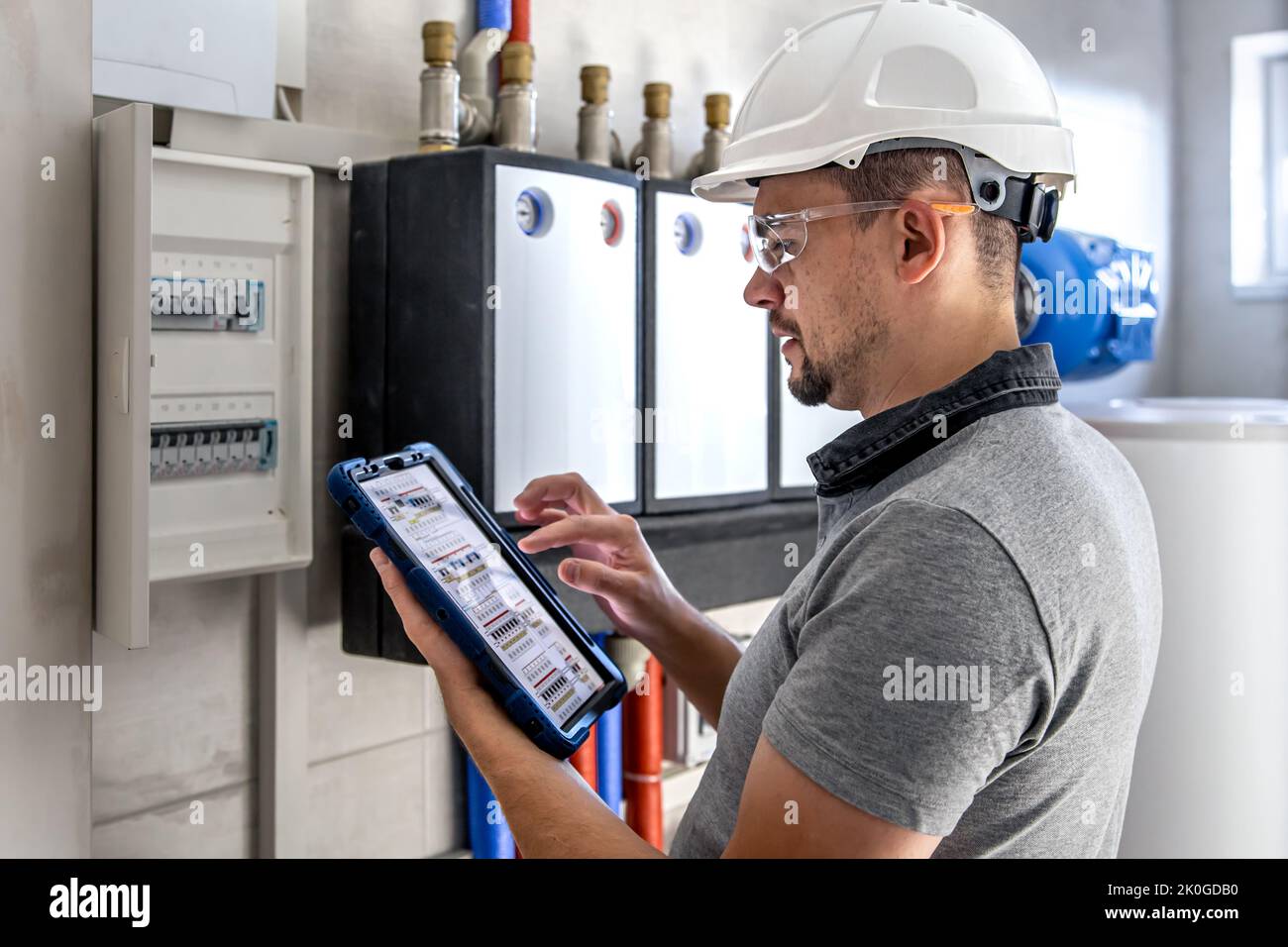 Electrical technician looking focused while working in a switchboard ...