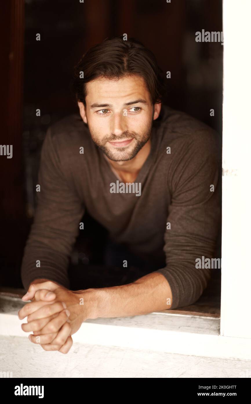 He takes a casual view of life. A handsome young man leaning out of ...