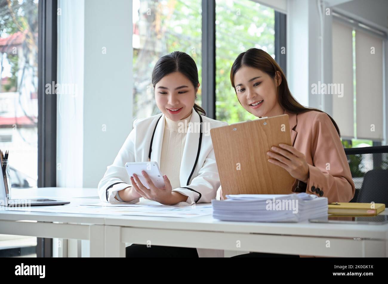 Two beautiful and attractive young Asian businesswomen or female ...