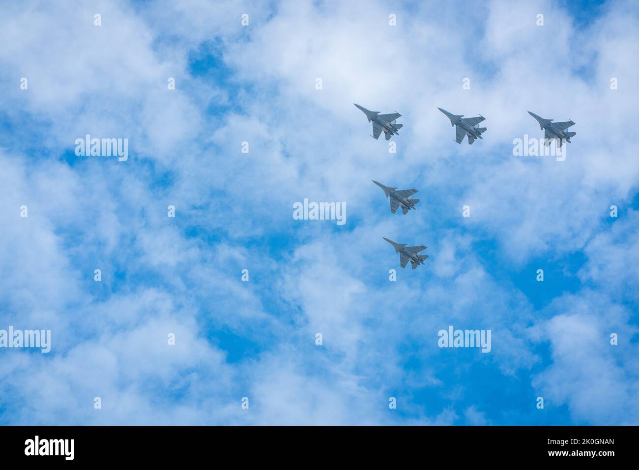 Military aircraft flying high in the blue sky with clouds Stock Photo ...