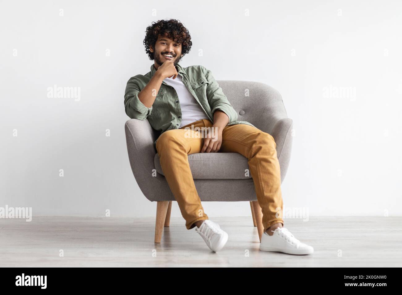 Relaxed indian guy chilling in arm chair over white background Stock ...