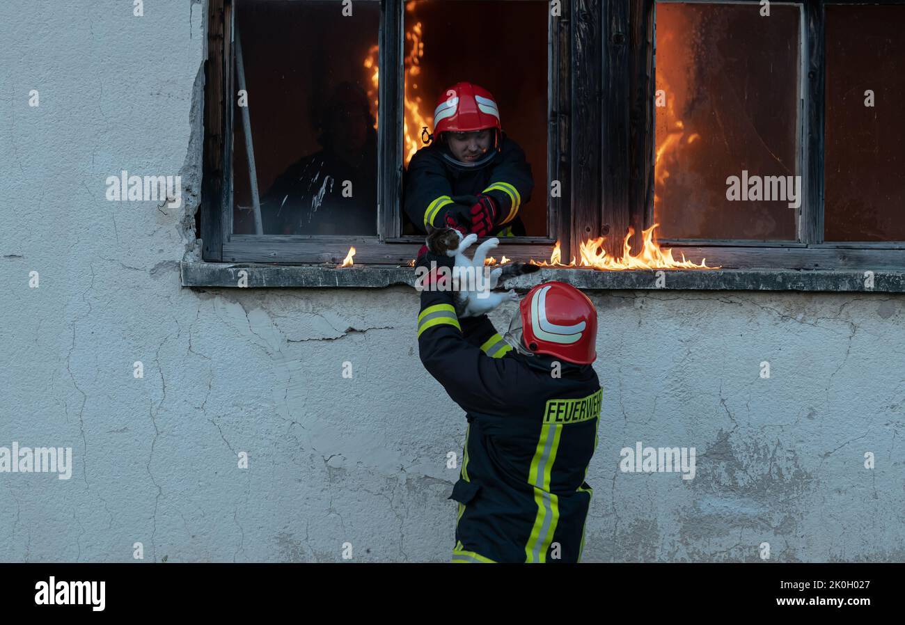 Firefighter hero carrying baby girl out from burning building area from ...