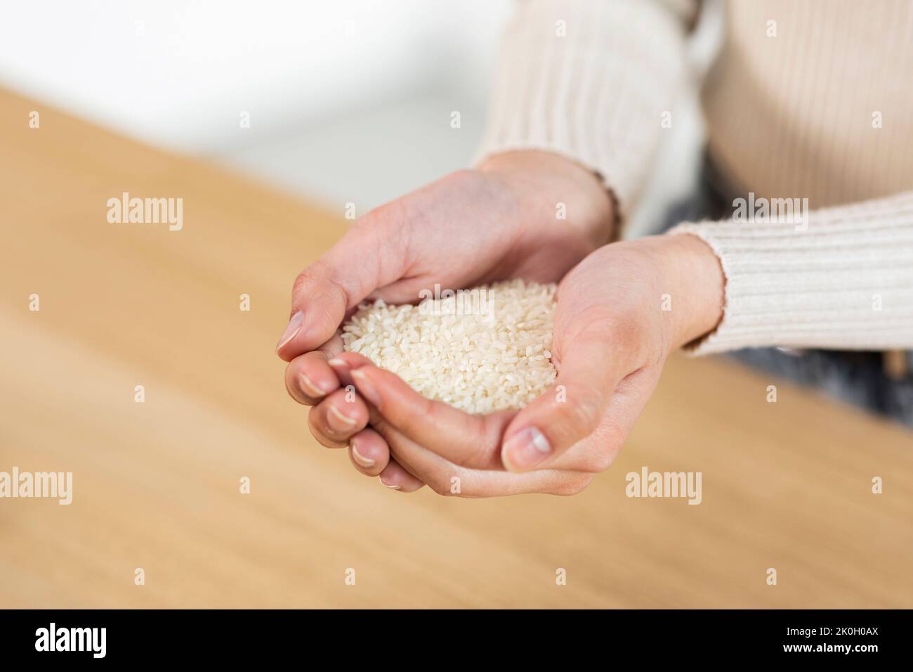 Female hands with handful of rice, cropped shot Stock Photo - Alamy