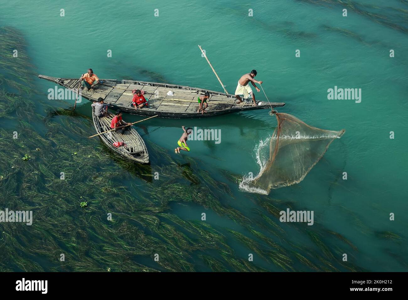 Fishermen floating on top of algae trying to catch fish in the green ...