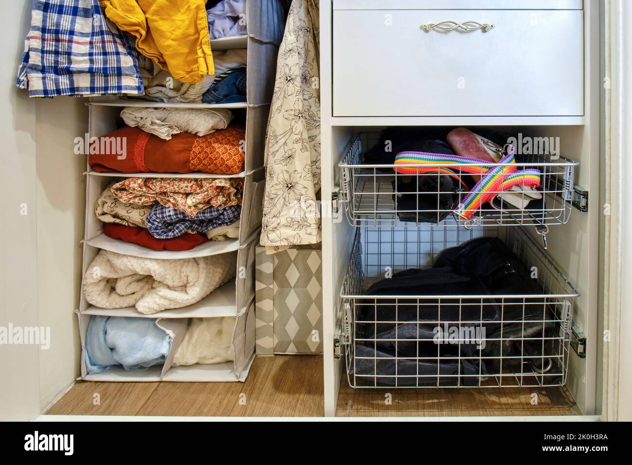 Open closet with women in the shelf, female dresses and shirts in the ...