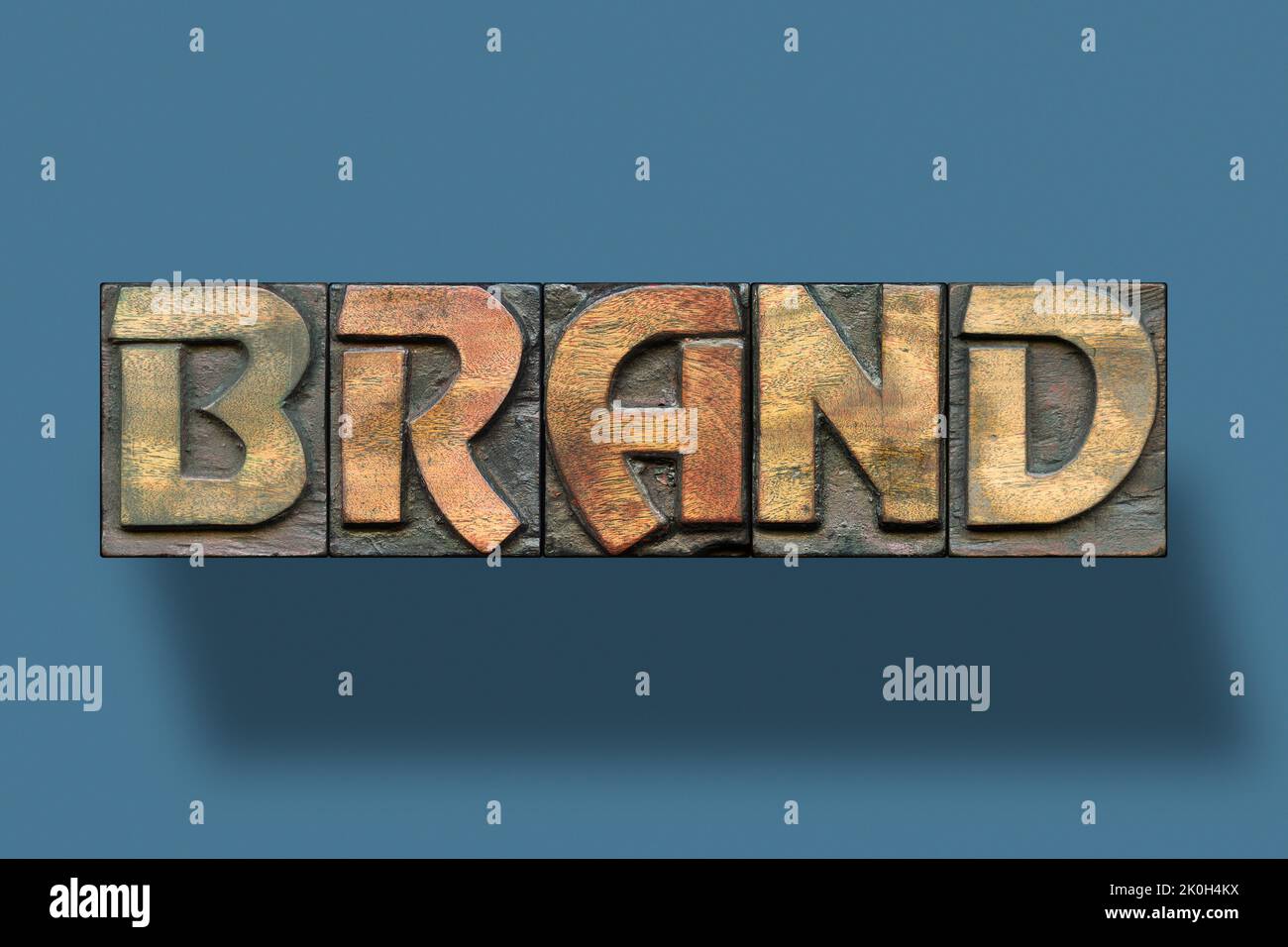 brand word made from wooden letterpress type with shadow on dark blue ...