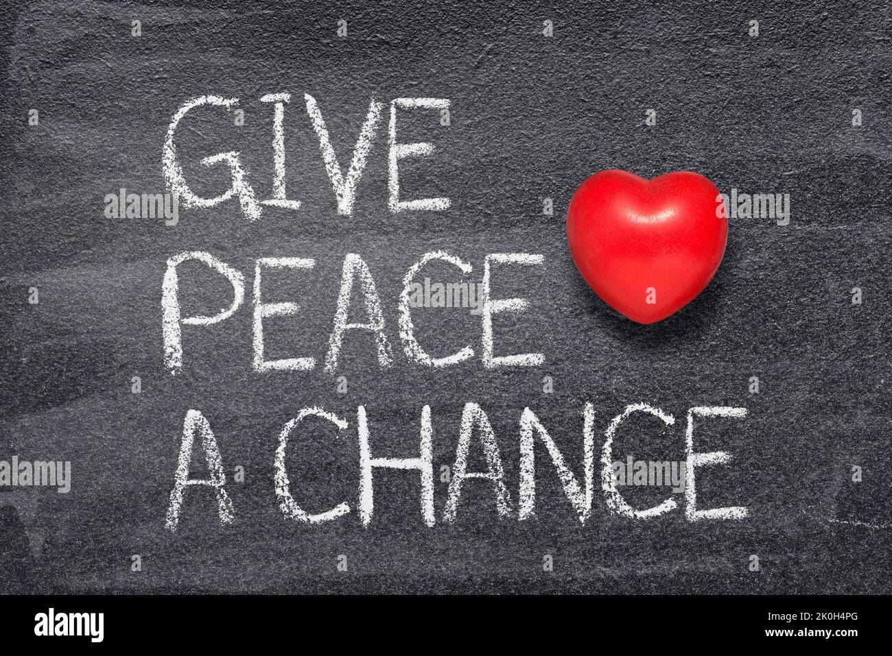 give peace a chance phrase written on chalkboard with red heart symbol ...