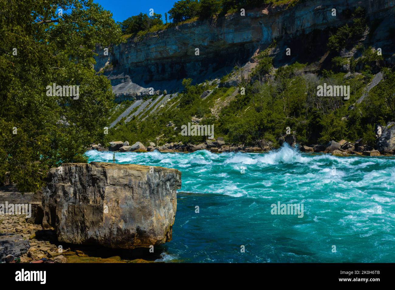 A scenic view of a blue crystal clear river with rocky shores in the ...