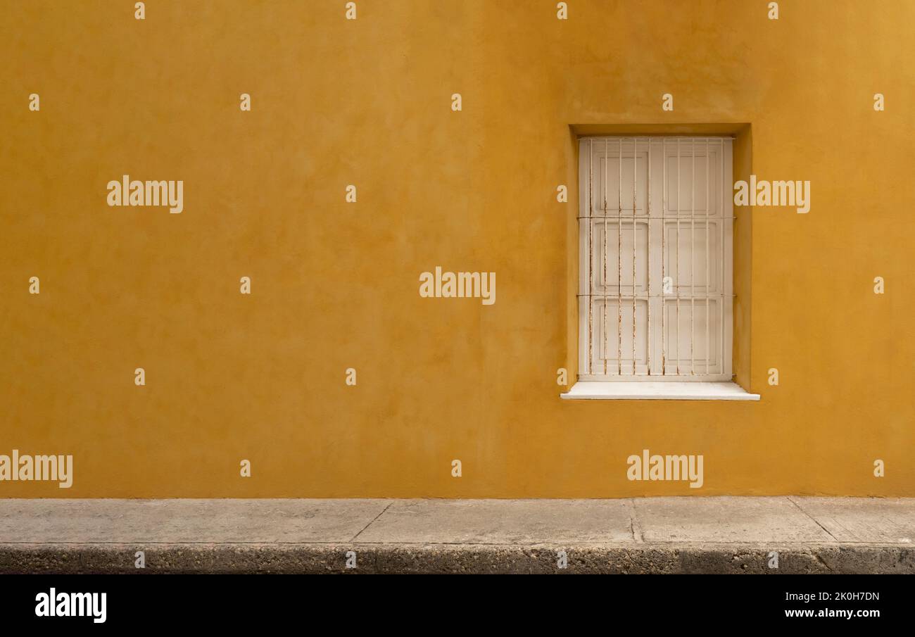 White window on panoramic yellow wall background and sidewalk ...