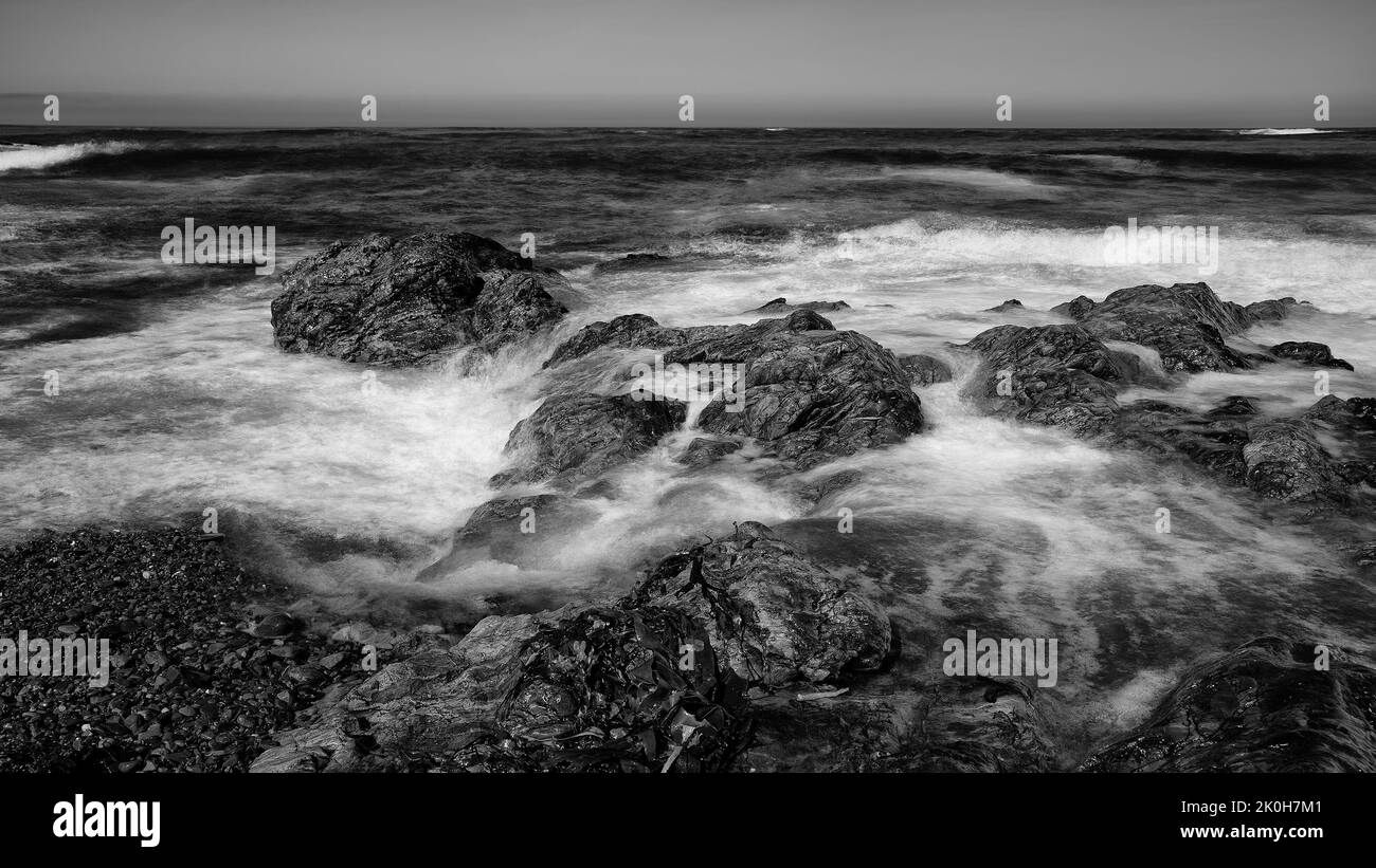A beautiful grayscale of sea waves crashing on rocks Stock Photo - Alamy