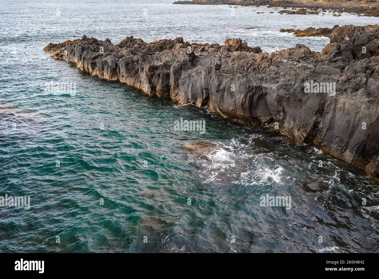 Basalt rocks in the ocean. Volcanic texture of vertical columns at the ...