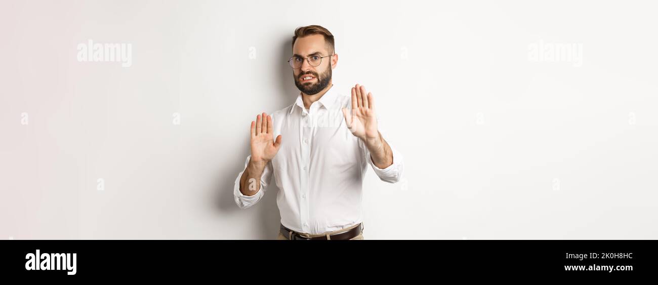 Displeased man rejecting something disturbing, showing stop sign and ...