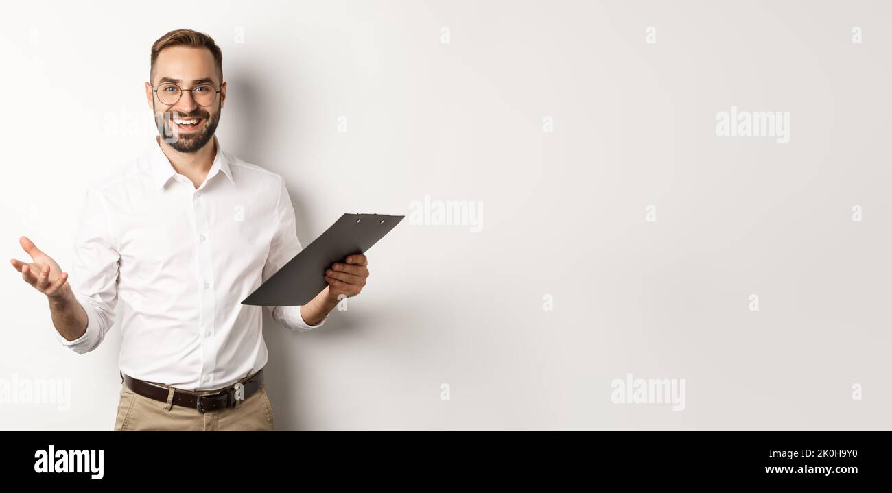 Handsome boss looking satisfied, holding clipboard and praising you ...