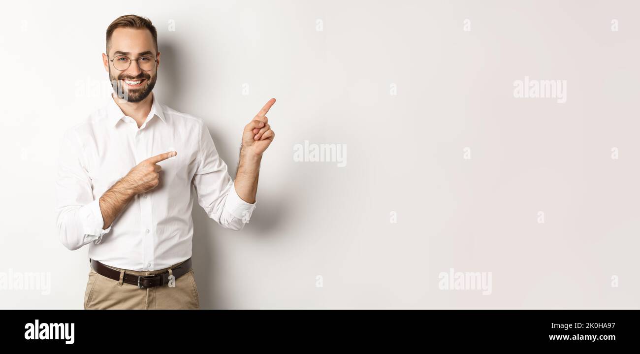 Handsome successful businessman pointing fingers right, showing ...