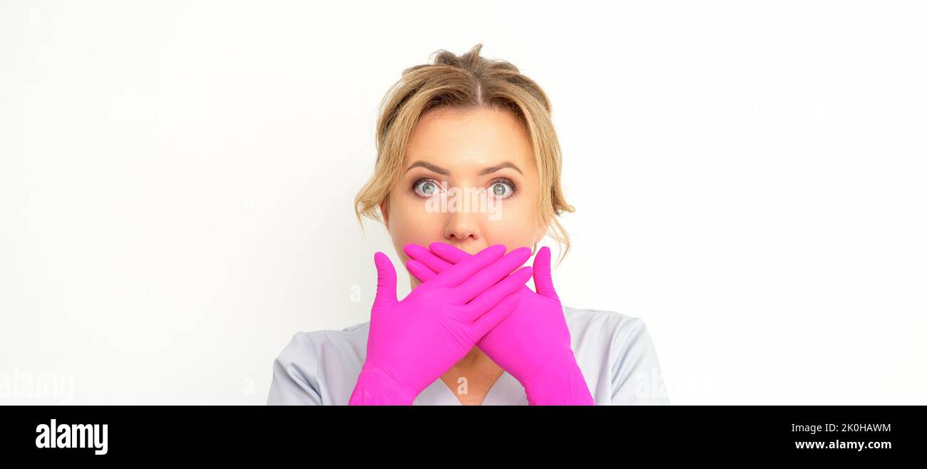 Portrait of a young female caucasian doctor or nurse is shocked ...