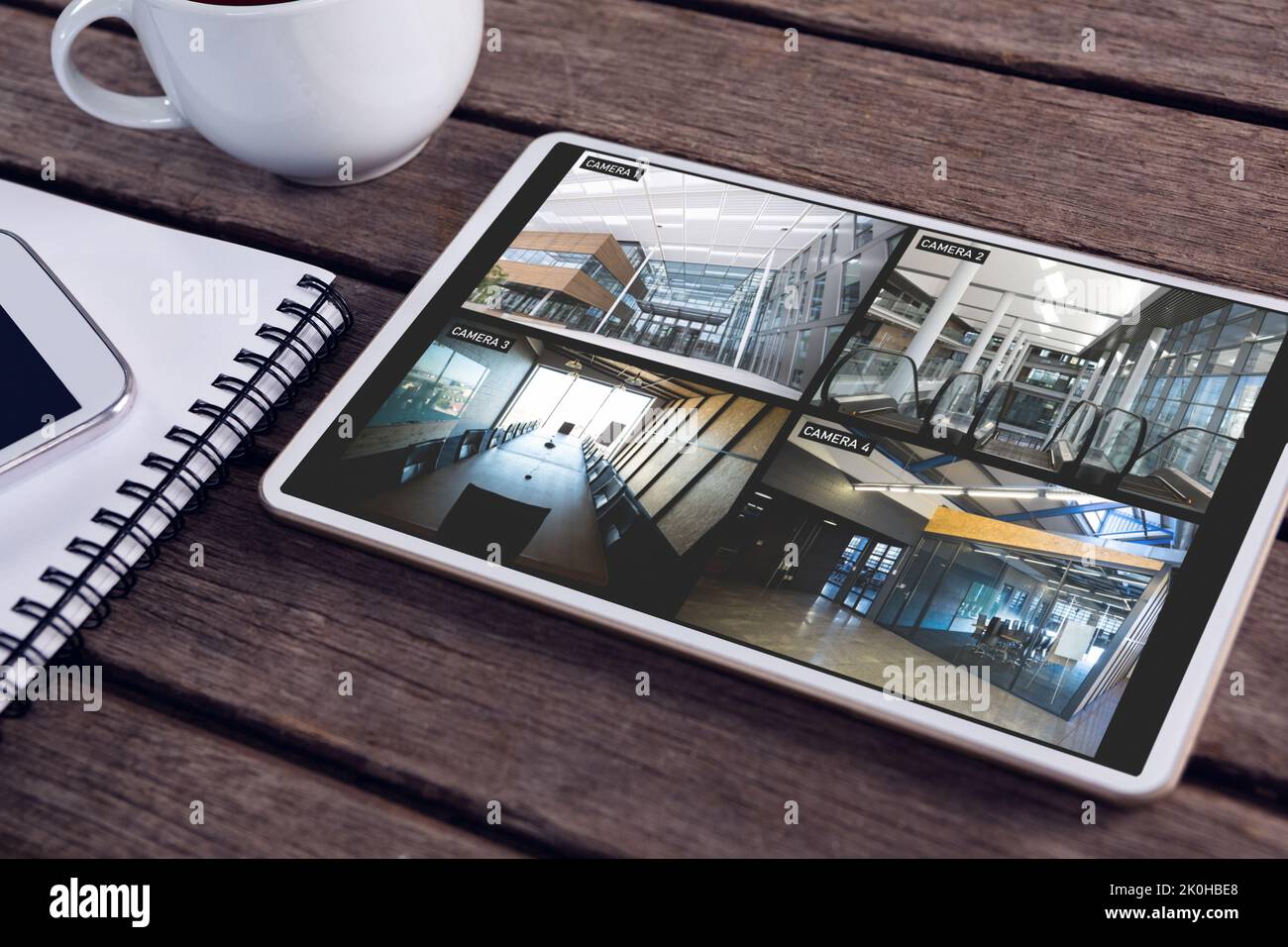 Tablet with views of offices from security cameras on screen lying on ...