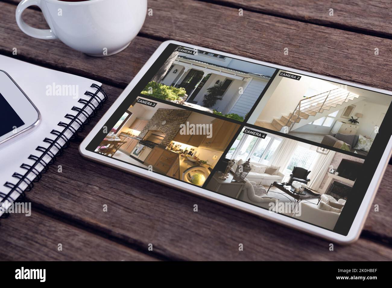 Tablet with views of home from security cameras on screen lying on ...
