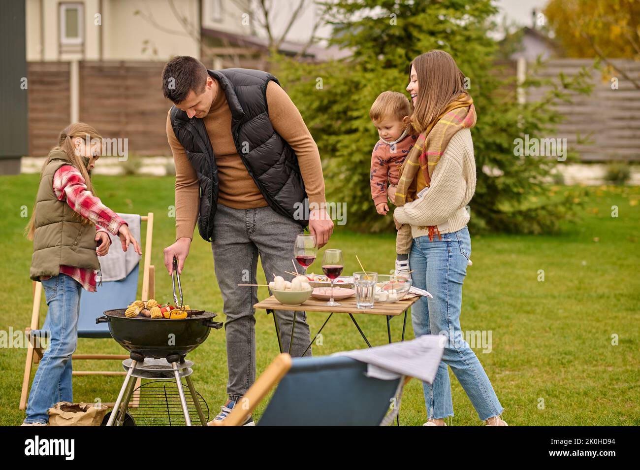 Family man cooking food for his wife and kids outdoors Stock Photo - Alamy