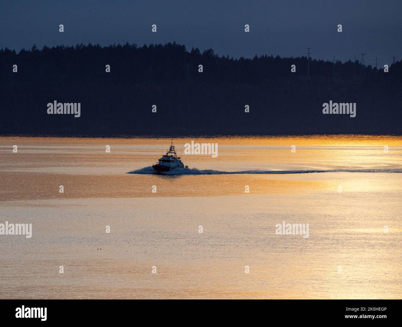 A golden sunset over the sea with a boat sailing Stock Photo - Alamy