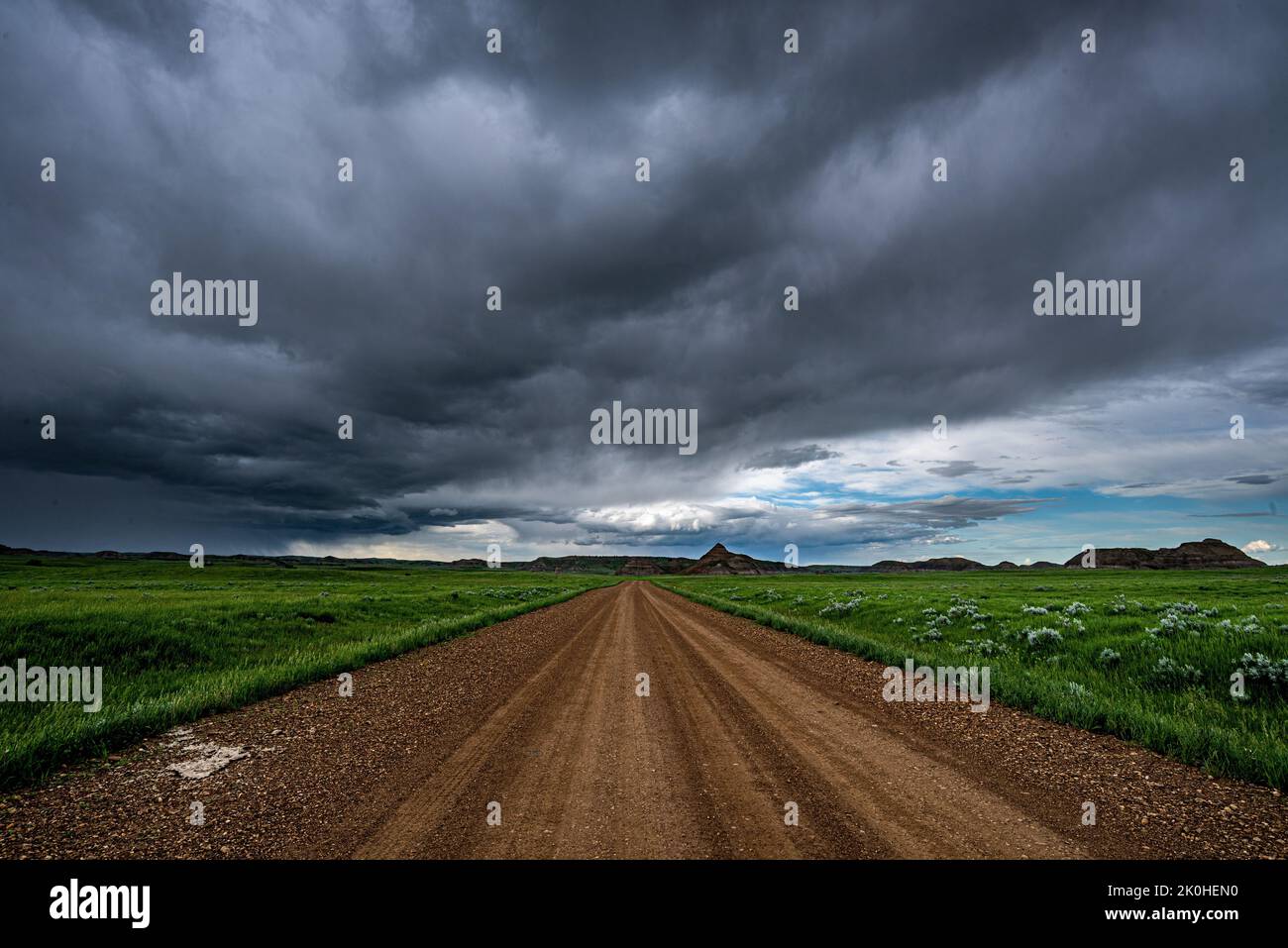 A muddy road with a dark clouds above Stock Photo - Alamy