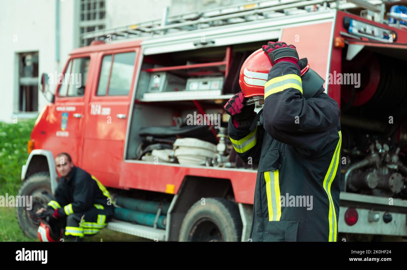 Firefighter with uniform and helmet stand in front of electric wire on ...