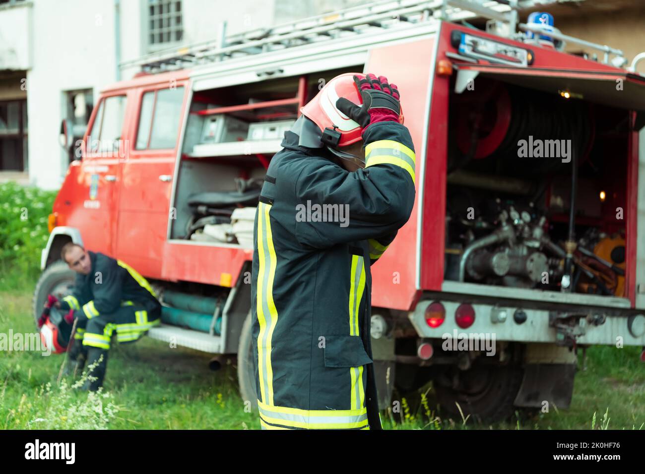 Firefighter with uniform and helmet stand in front of electric wire on ...