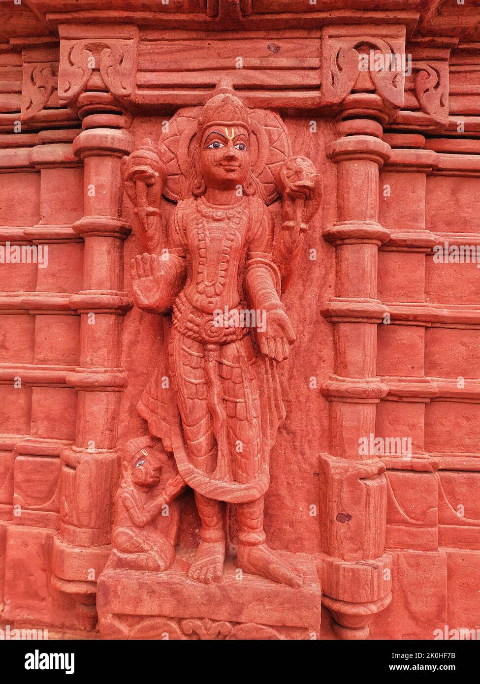 A vertical shot of a religious god's statue on a red wall Stock Photo ...