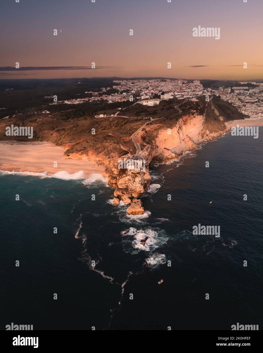 A vertical aerial view of the coast along a blue ocean in a colorful ...