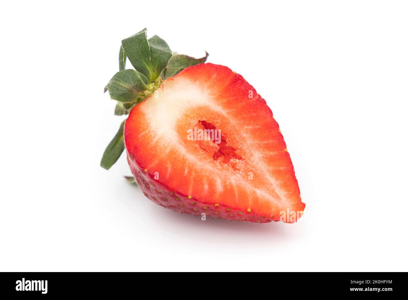 A strawberry cut in half isolated on a white background Stock Photo - Alamy