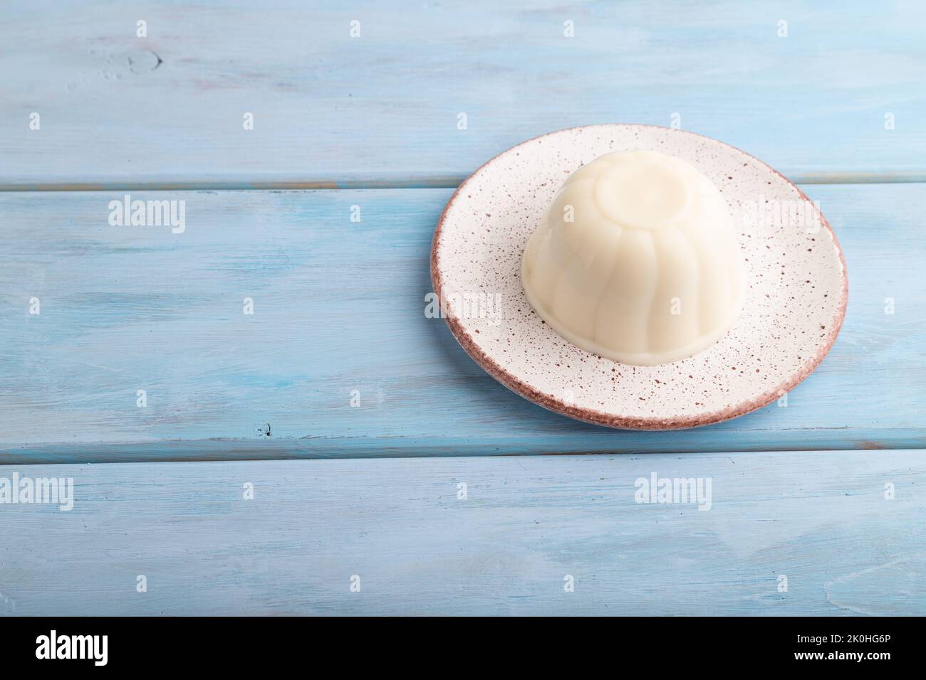 White milk jelly on blue wooden background. side view, copy space Stock ...