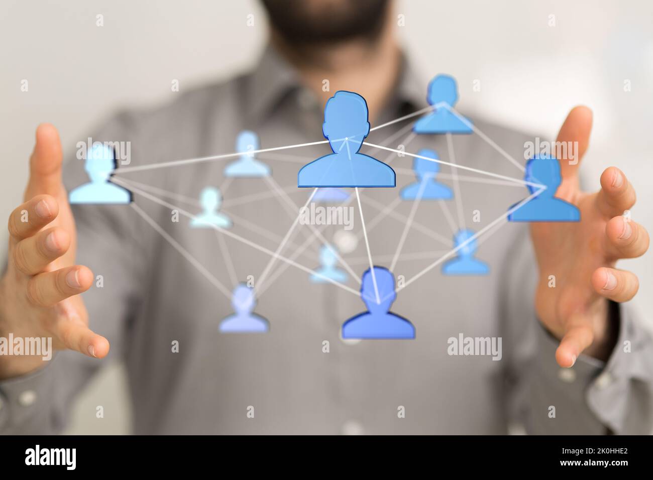 A person showing 3d human icons on a blurred background Stock Photo - Alamy