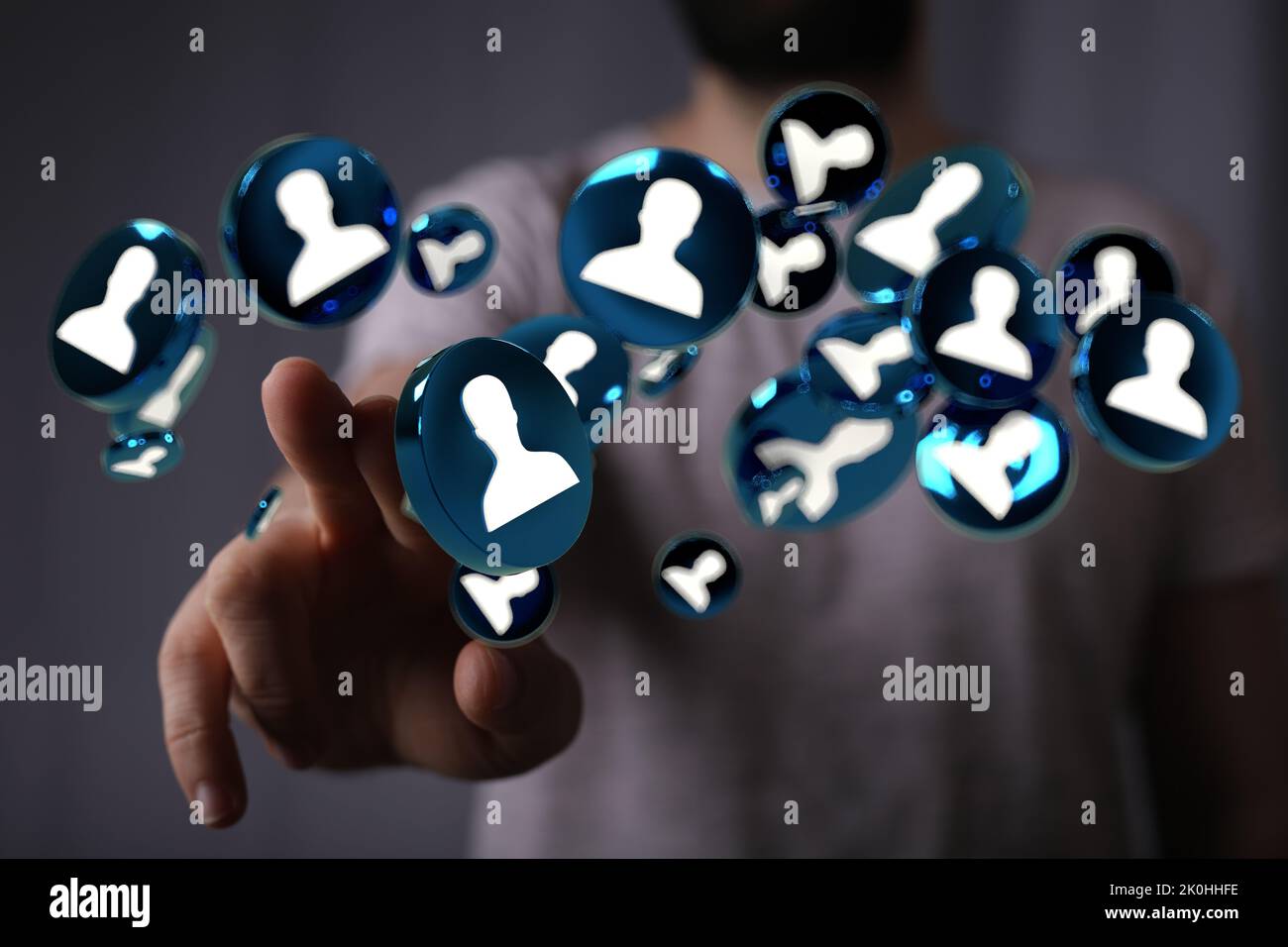A person showing 3d human icons on a blurred background Stock Photo - Alamy