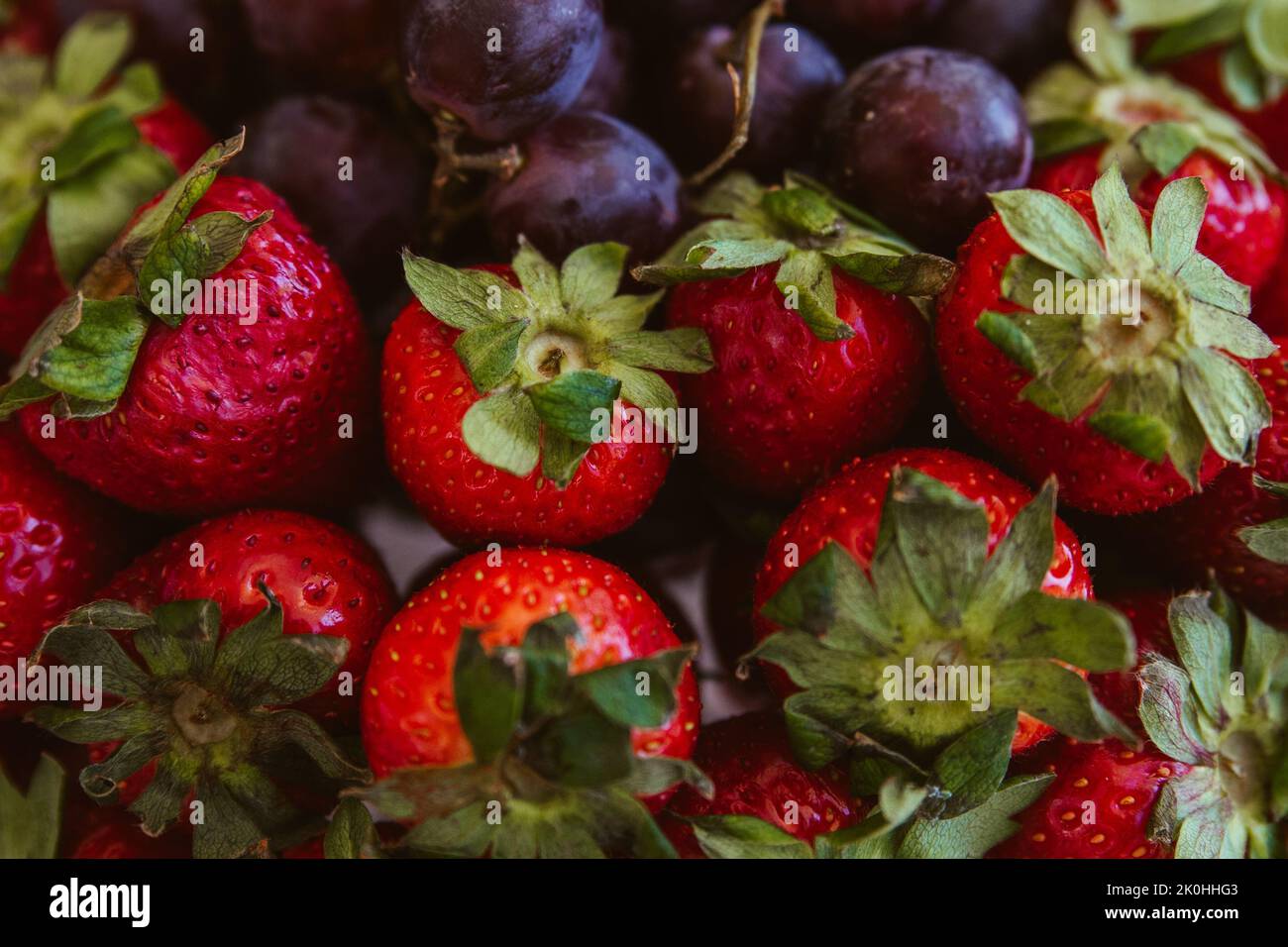 A close up of strawberries and black grapes Stock Photo - Alamy