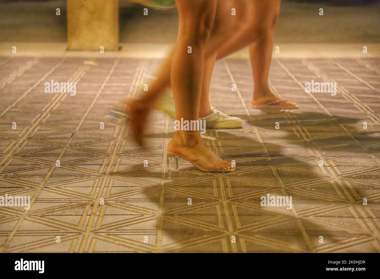 A close-up shot of people's feet walking on the ground Stock Photo - Alamy