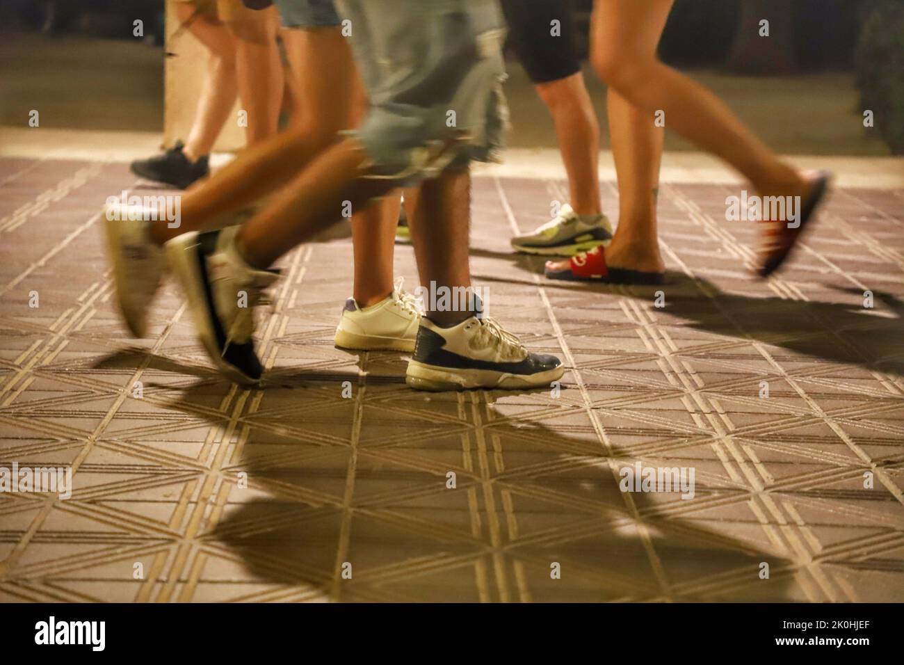 A close-up shot of people's feet walking on a floor Stock Photo - Alamy
