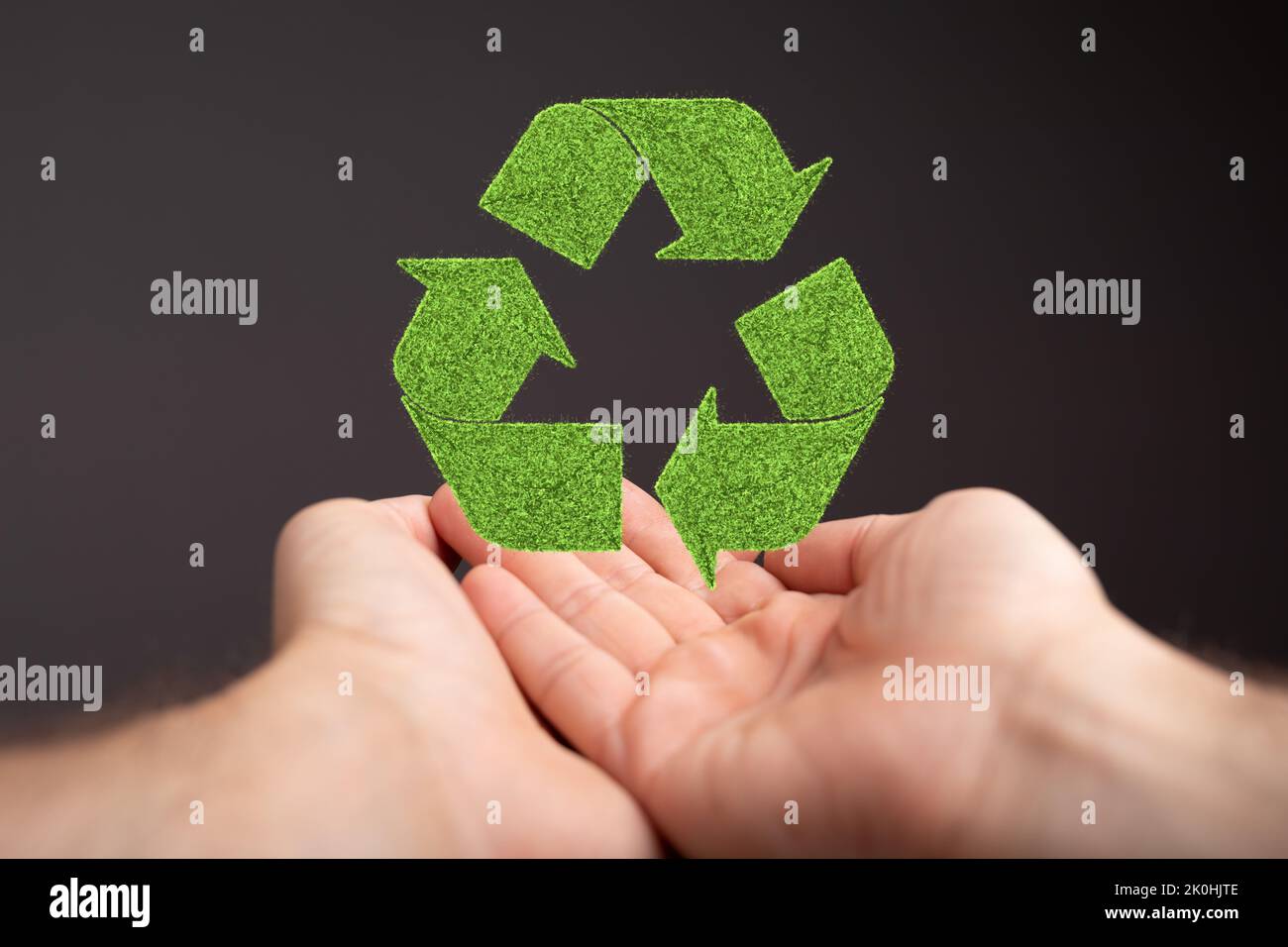 The hands holding the recycle sign before the black background Stock ...