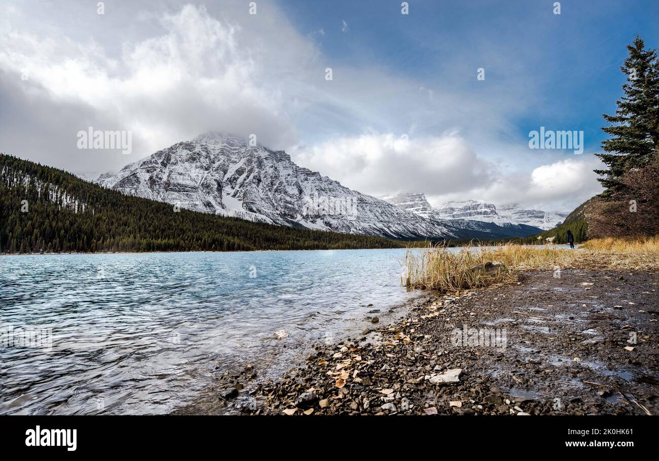 A beautiful shot of lakeshore with the background of a snowy mountain ...