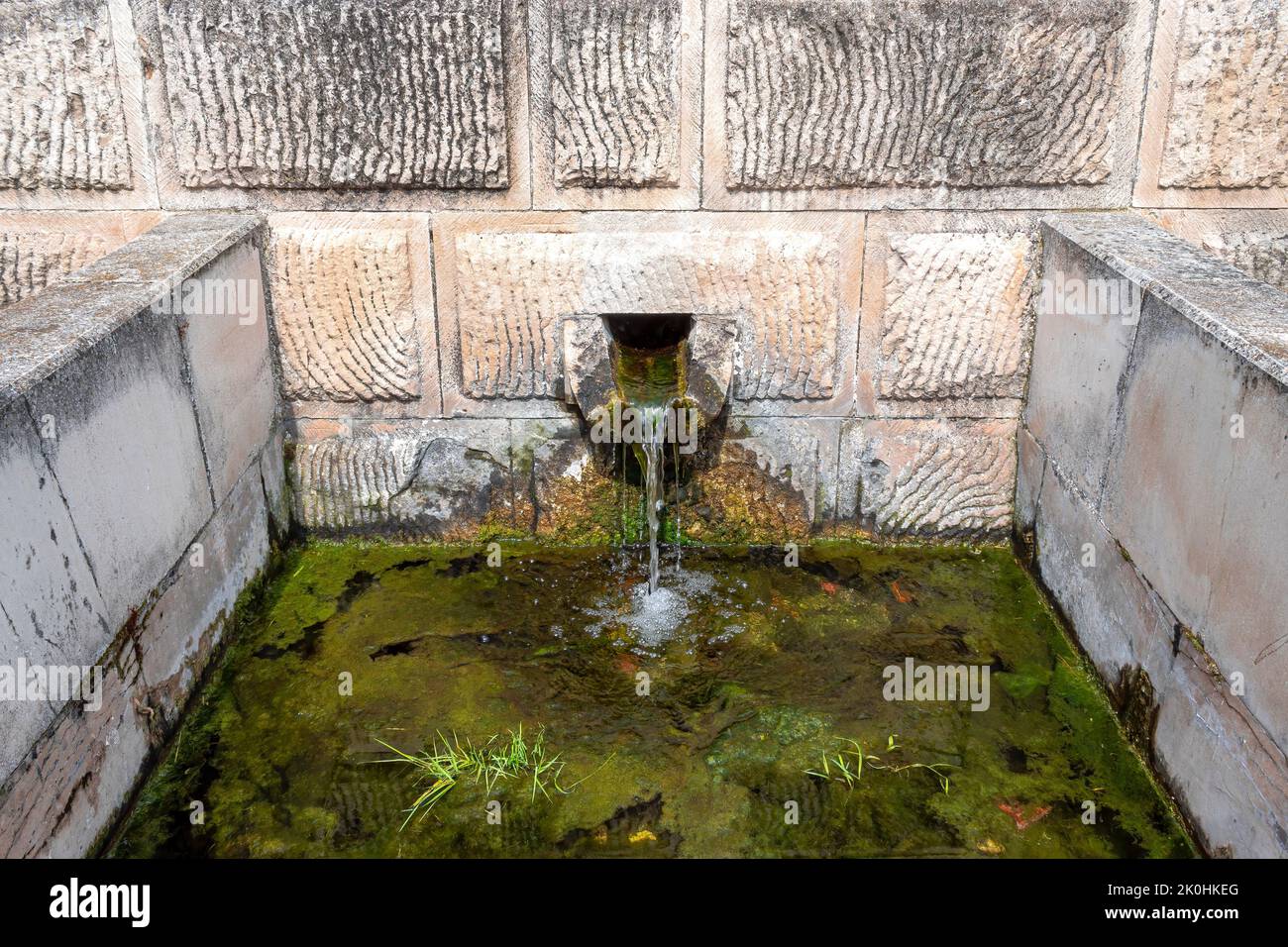 A well flows from an old building Stock Photo - Alamy