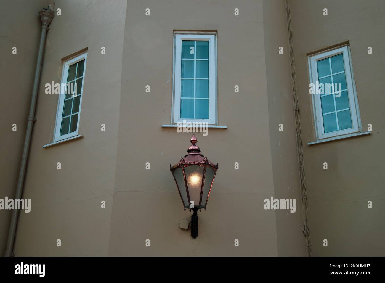 A beautiful lantern hanging on a wall under a window Stock Photo - Alamy