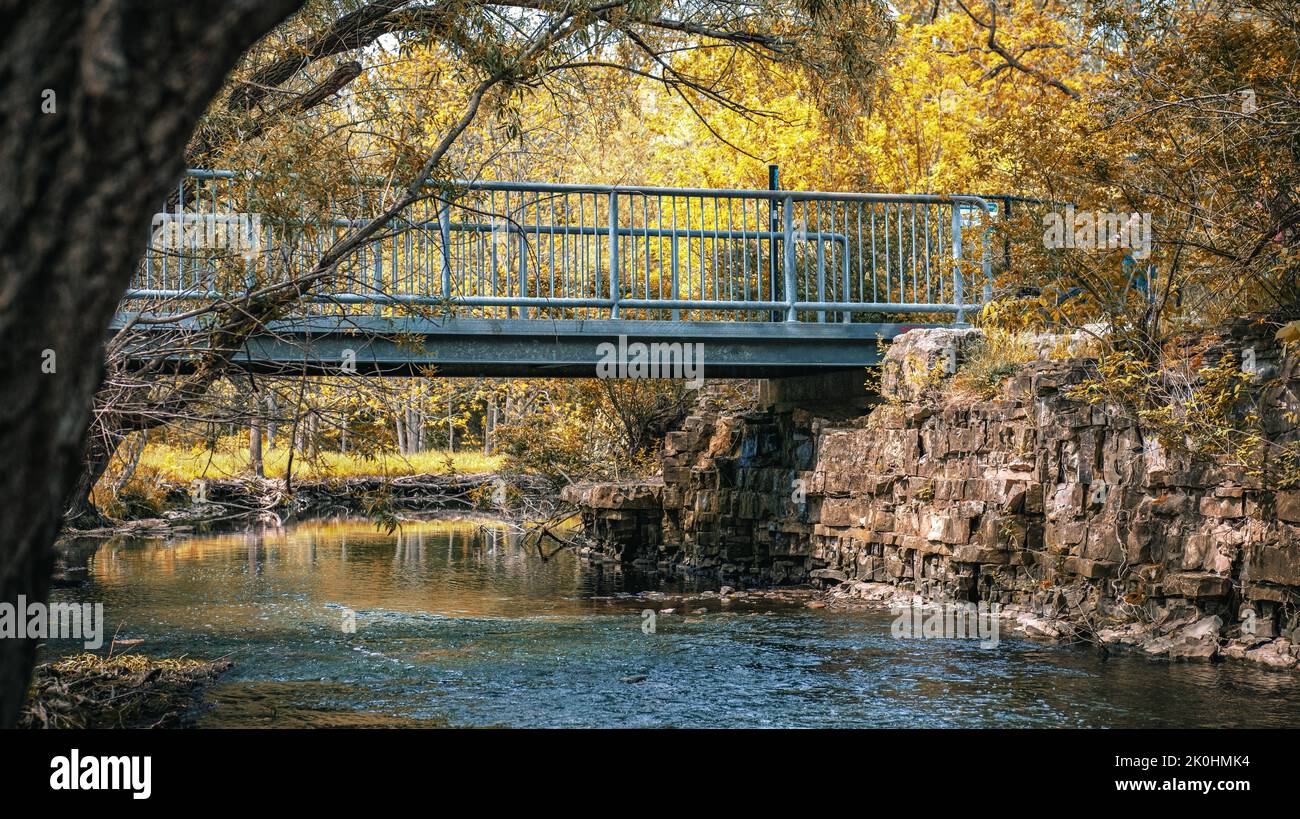 A natural scenery of a metal bridge stretched over a river captured in ...
