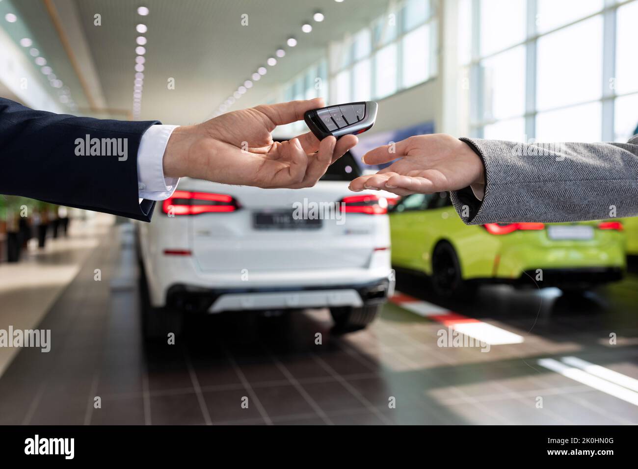 handing over the keys close-up by the seller of the car dealership to ...