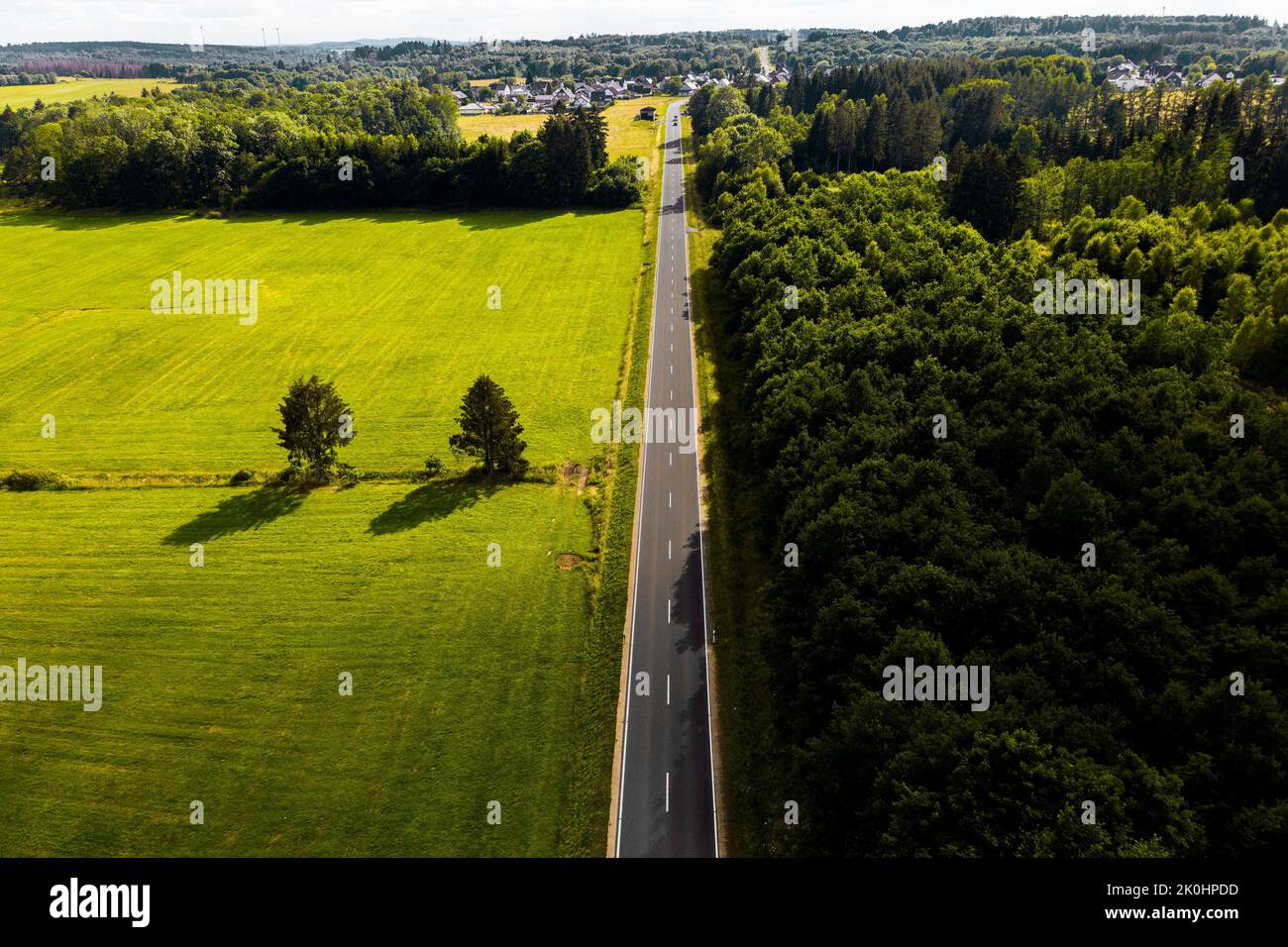 The aerial view of a straight road leading to the town and splitting ...