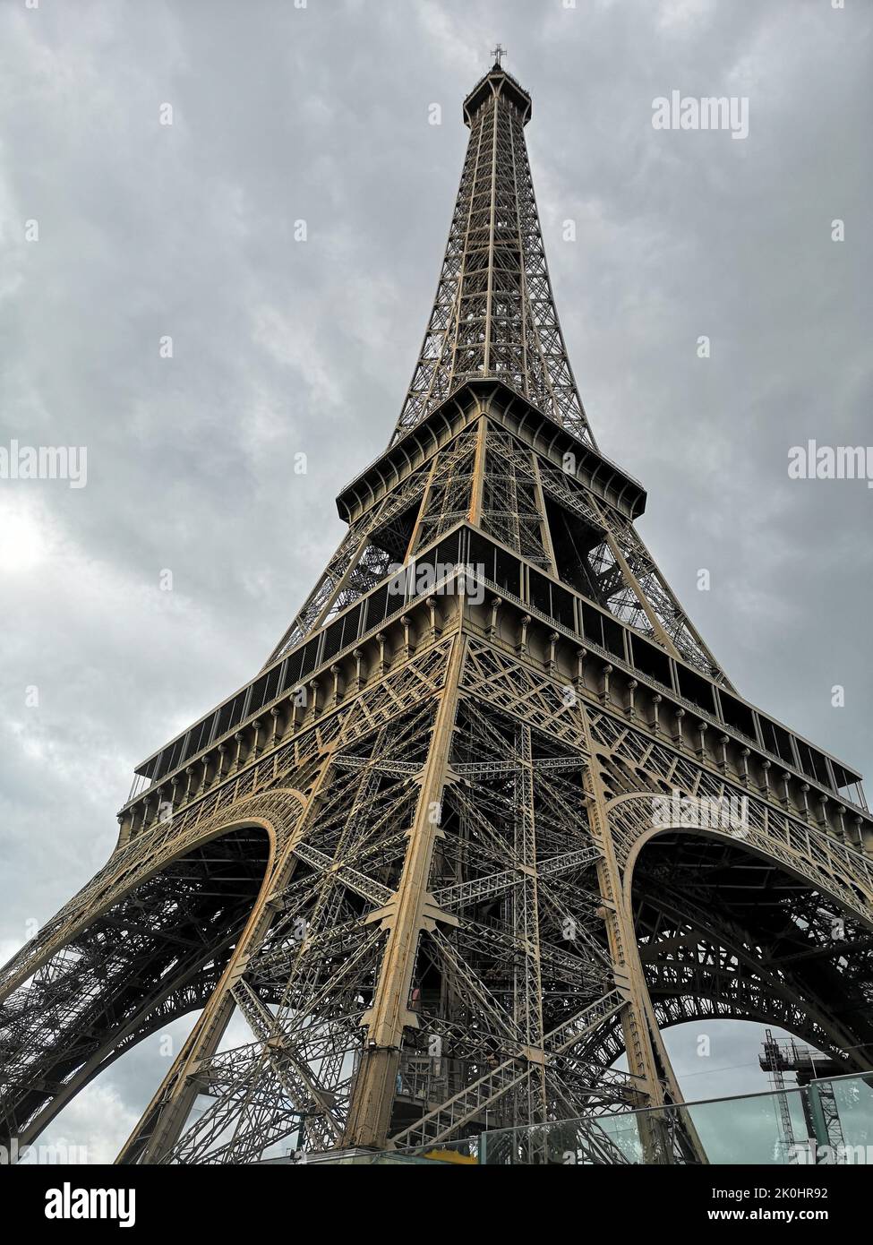 A vertical low angle shot of the Eiffel tower in Paris against cloudy ...