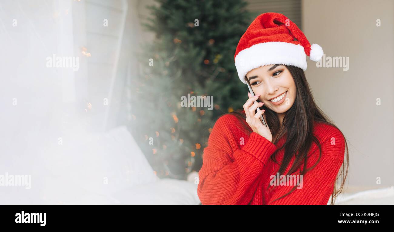 Young beautiful asian woman with dark long hair in cozy red knitted ...